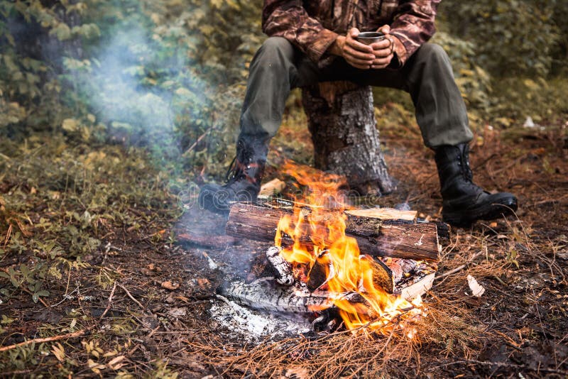 The Man Sitting by the Fire in the Forest. Stock Photo - Image of ...