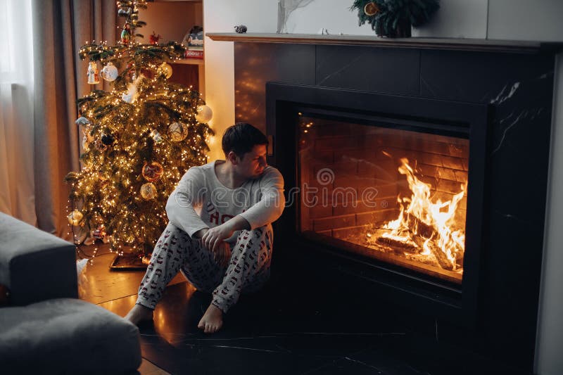 A Man is Sitting by the Fireplace and Looking at the Fire Stock Image ...