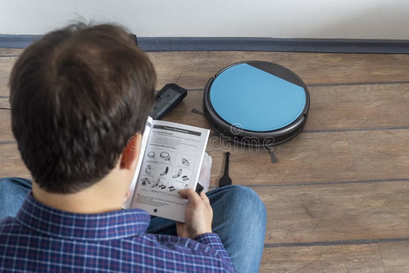 Reading the User Guide for Robot Vacuum Cleaner Stock Image - Image of ...