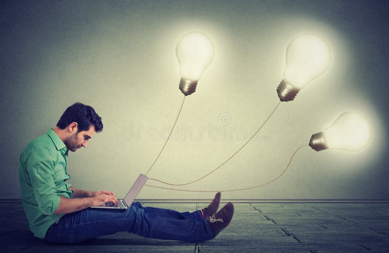 Man Sitting on Floor Using a Laptop with Many Light Bulbs Plugged in it ...