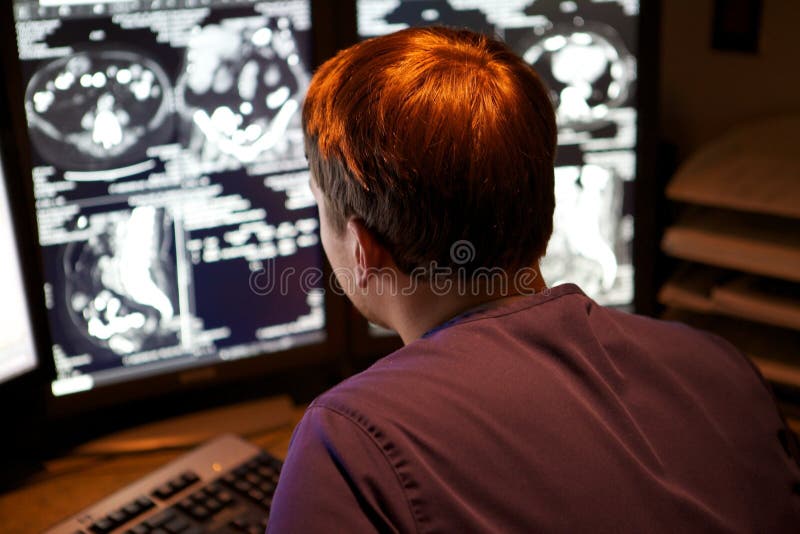 Man Sitting in Front of the Computer and Watching X-rays Under the ...