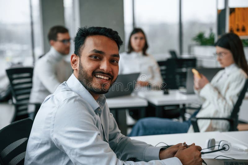 Man is Sitting in Front of His Colleagues. Four People are Working in ...