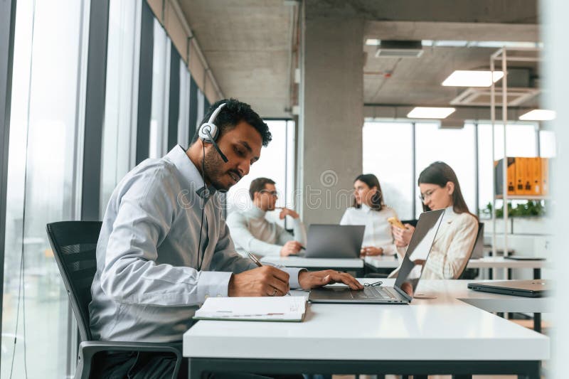 Man is Sitting in Front of His Colleagues. Four People are Working in ...