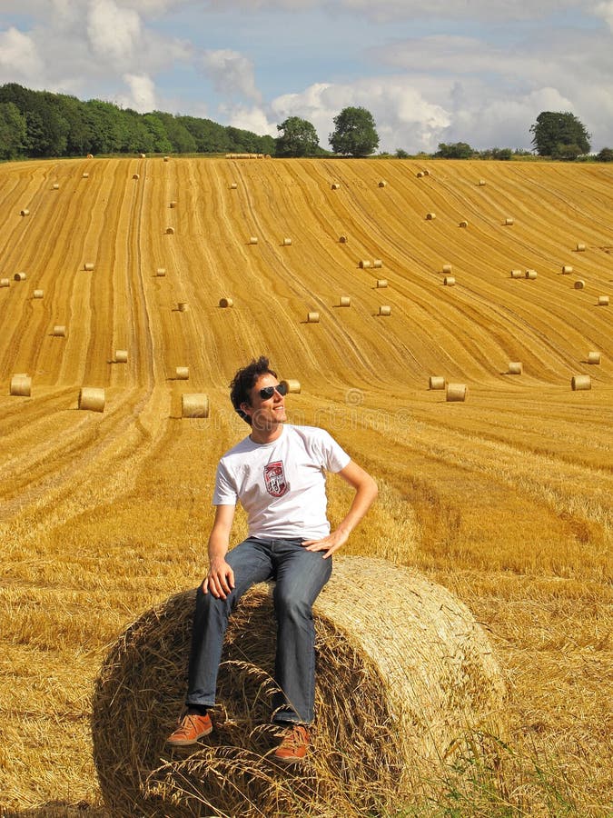 Man sitting on hay bale stock photo. Image of straw, idyllic - 34308408