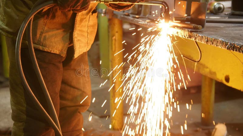 A Man Sitting at His Workplace and Using a Welding Machine. Heating Up ...