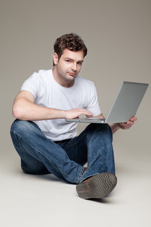 Man Sitting and Holding Laptop Stock Photo - Image of smile, searching ...