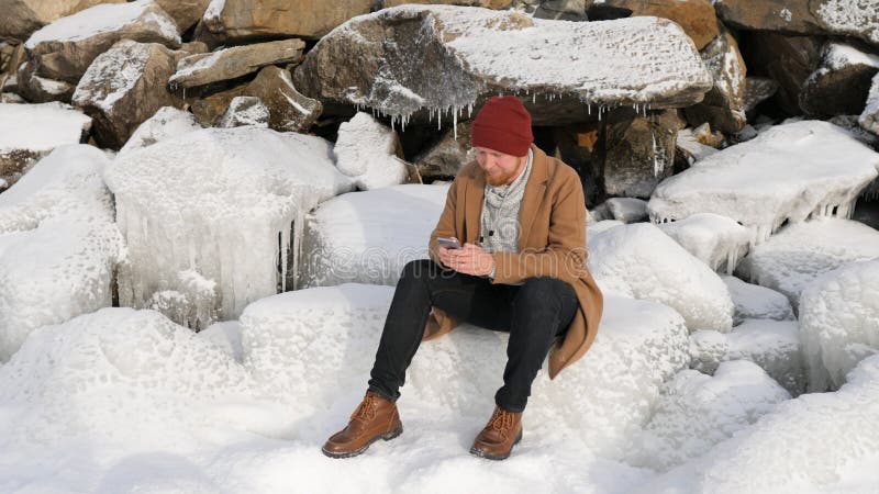 Man Sitting on the Ice and Talking on the Phone Stock Photo - Image of ...