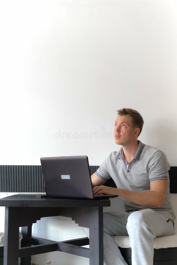 Man Sitting Indoors while Using Laptop Computer while Thinking Stock ...