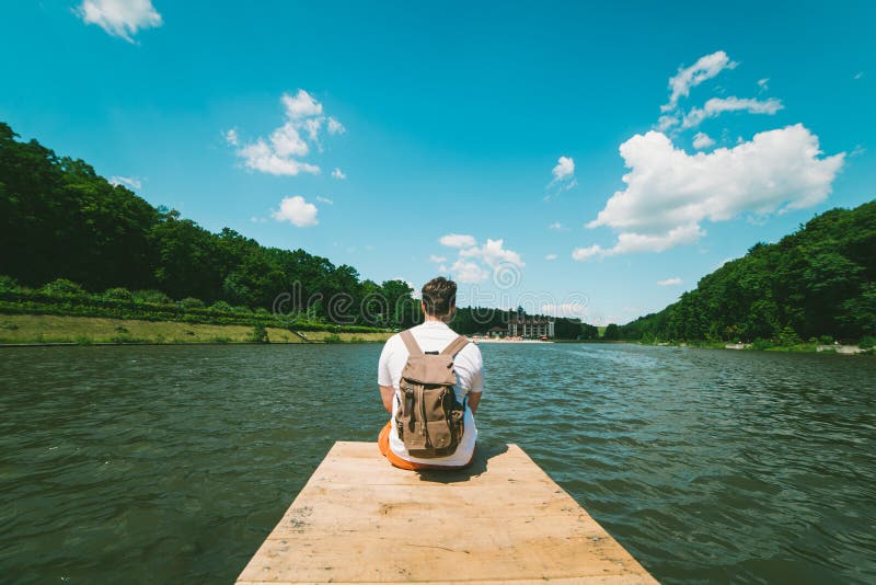 Man sitting on a lake pier stock photo. Image of male - 95209774