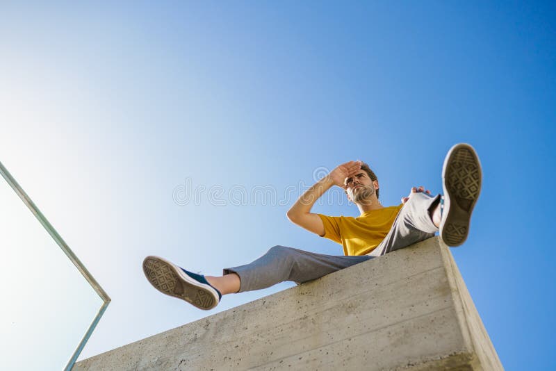Man sitting on a ledge stock image. Image of strange - 11504545