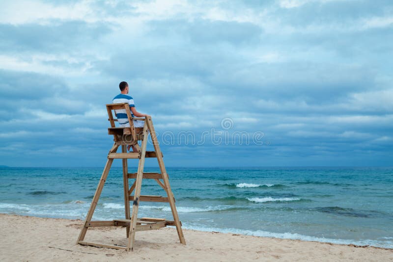 Man Sitting on Lifeguard Chair Stock Image - Image of alone, outdoor ...