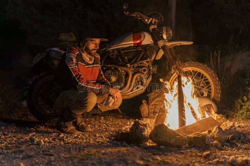 Man Sitting on a Motorcycle by the Fire Pit at Night Stock Photo ...