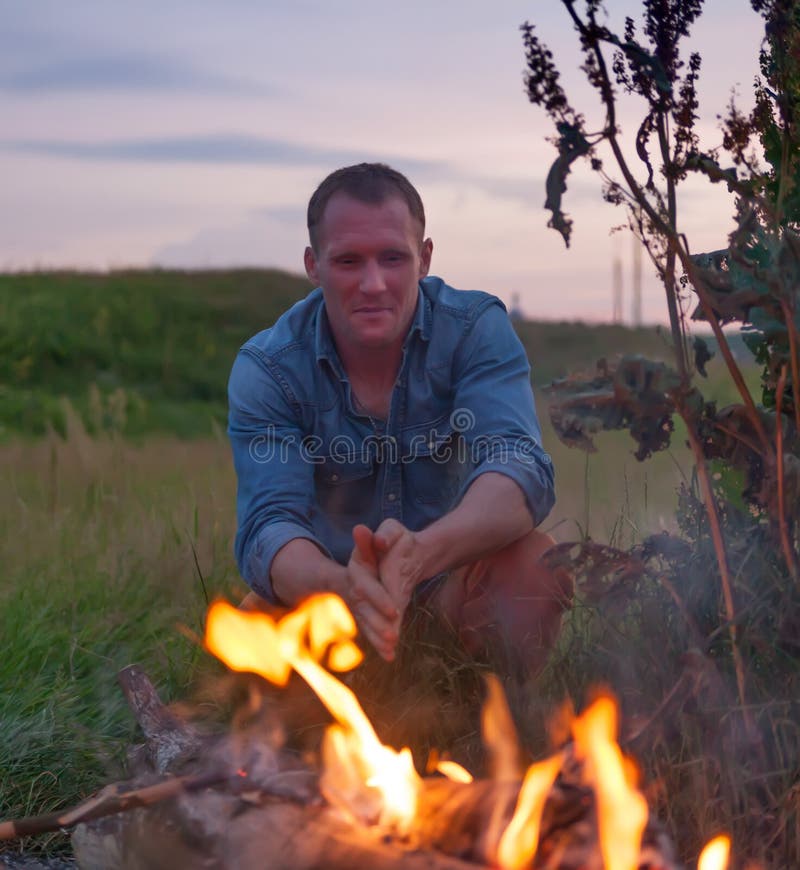 Man sitting near bonfire stock image. Image of wilderness - 59581809