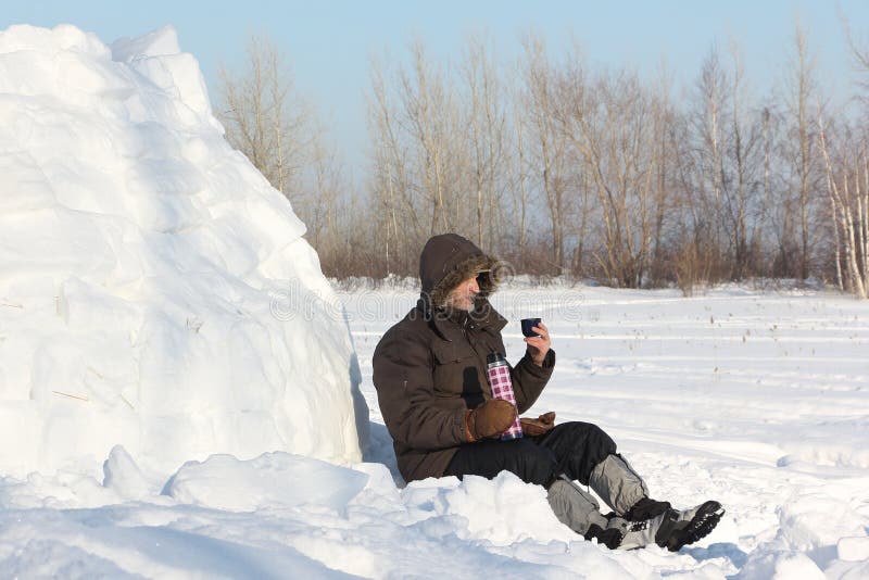 The Man Sitting Near an Igloo and Drinking Tea from Thermos Stock Photo ...