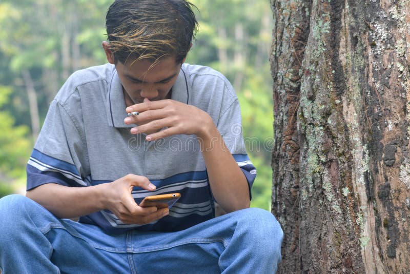 Man Sitting and Playing Cellphone Stock Photo - Image of interaction ...