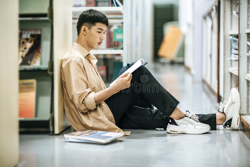 A Man Sitting Reading a Book in the Library Stock Photo - Image of ...