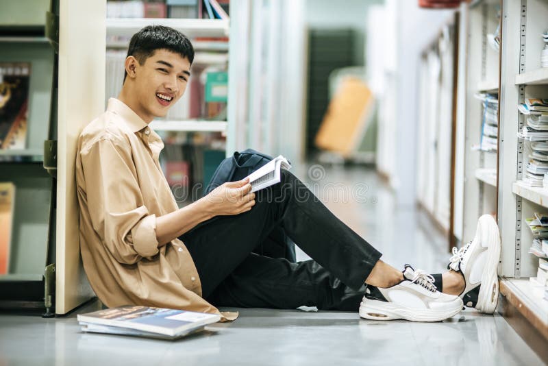 A Man Sitting Reading a Book in the Library Stock Photo - Image of ...
