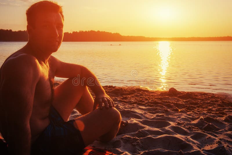Man Sitting on the Sand at Sunset Stock Image - Image of nature, ocean ...
