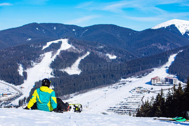 Man Sitting with Snowboard on the Top of the Hill with Beautiful View ...