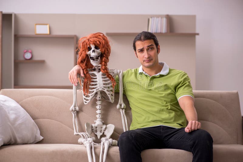 Young Man Sitting on the Sofa with Female Skeleton Stock Photo - Image ...