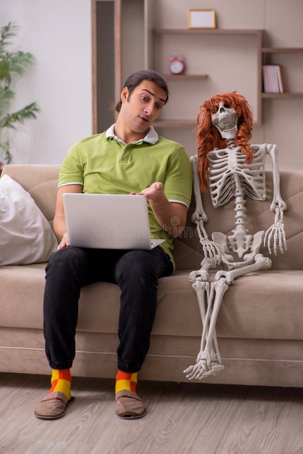 Young Man Sitting on the Sofa with Female Skeleton Stock Photo - Image ...