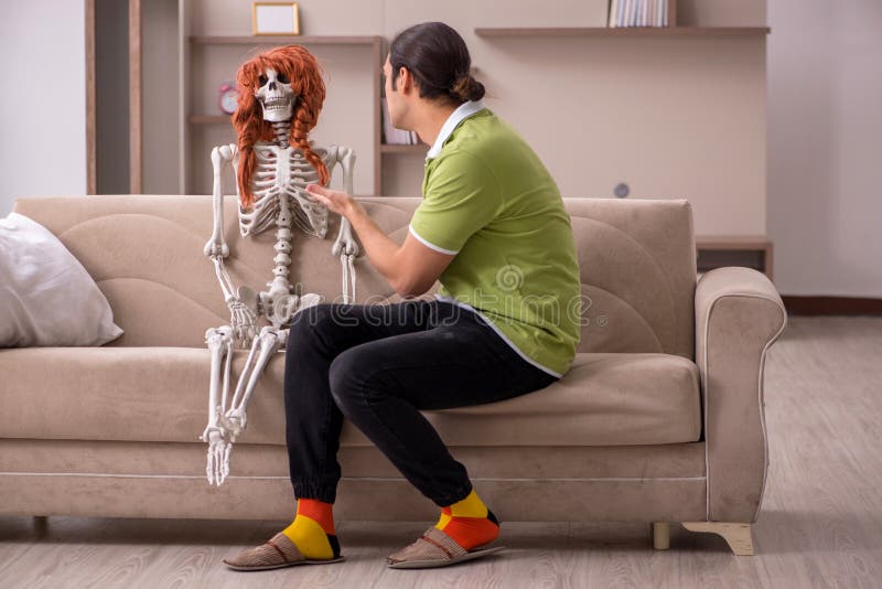 Young Man Sitting on the Sofa with Female Skeleton Stock Photo - Image ...