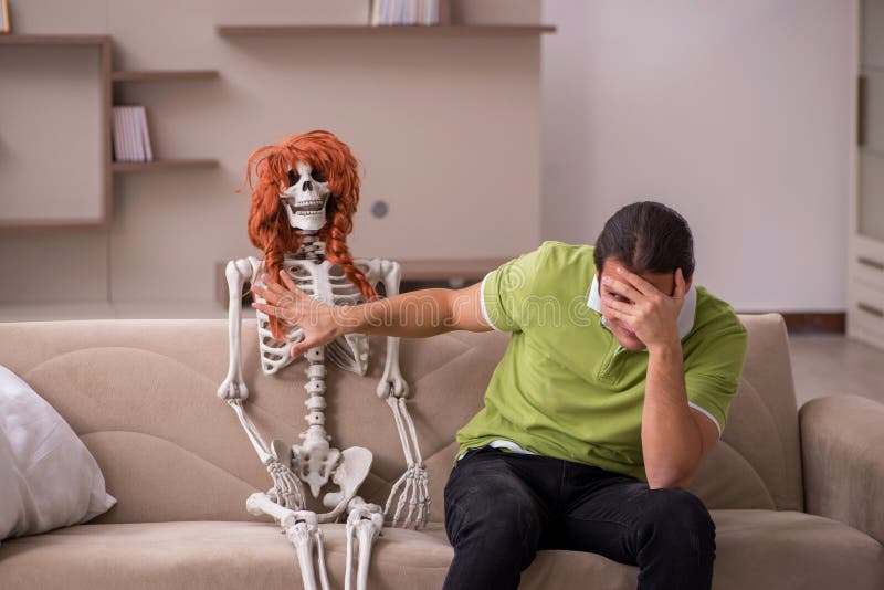 Young Man Sitting on the Sofa with Female Skeleton Stock Image - Image ...