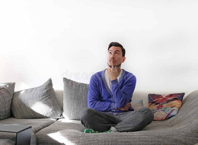Man Sitting on a Sofa Looking Up and Contemplating Stock Image - Image ...