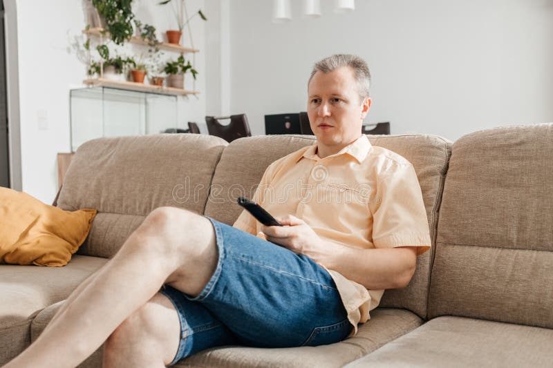 Man Sitting on the Sofa and Watching TV in His Free Time Stock Image ...