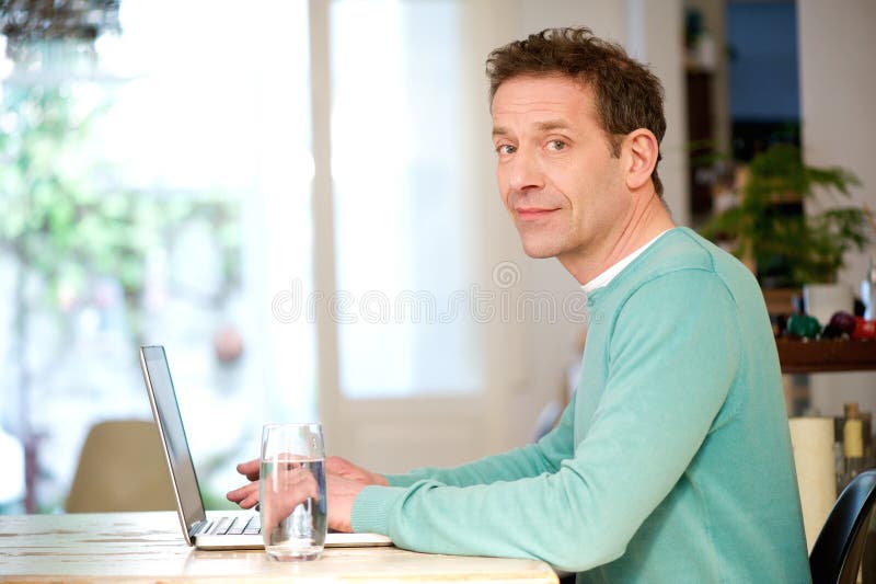 Man Sitting at Table with Laptop Stock Photo - Image of older, computer ...