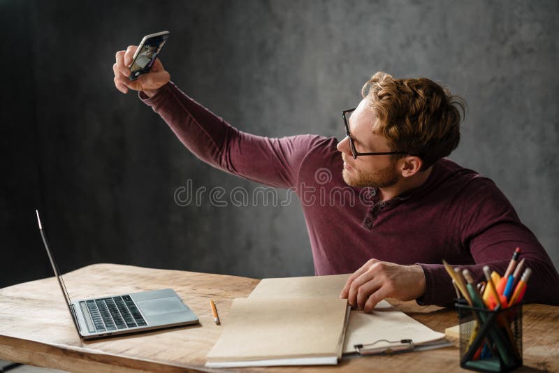 The Man Sitting at Table and Making Photos of Documents in the Studio ...