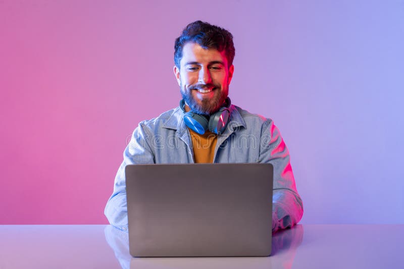Man Sitting at Table Using Laptop Computer Stock Photo - Image of ...