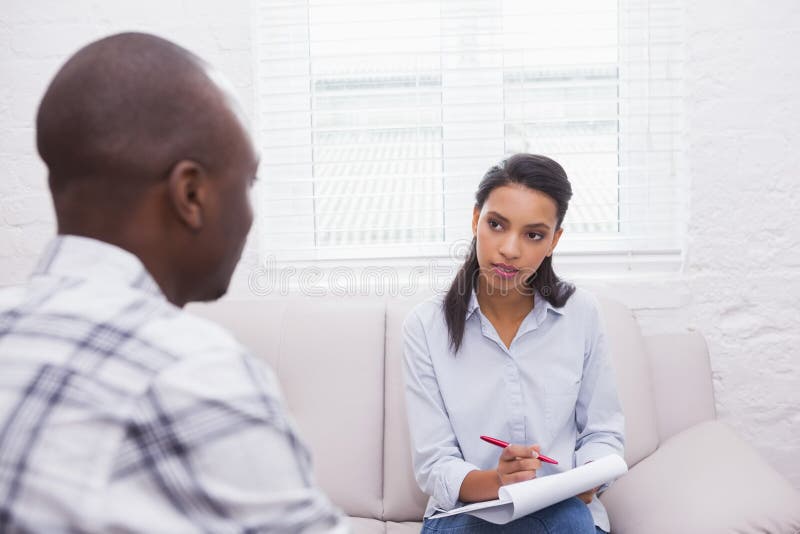 Man Sitting with Therapist Taking Notes Stock Image - Image of studio ...