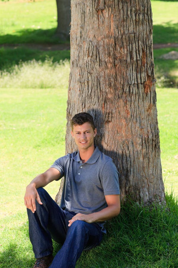Man sitting beside a tree stock photo. Image of outdoor - 18739702