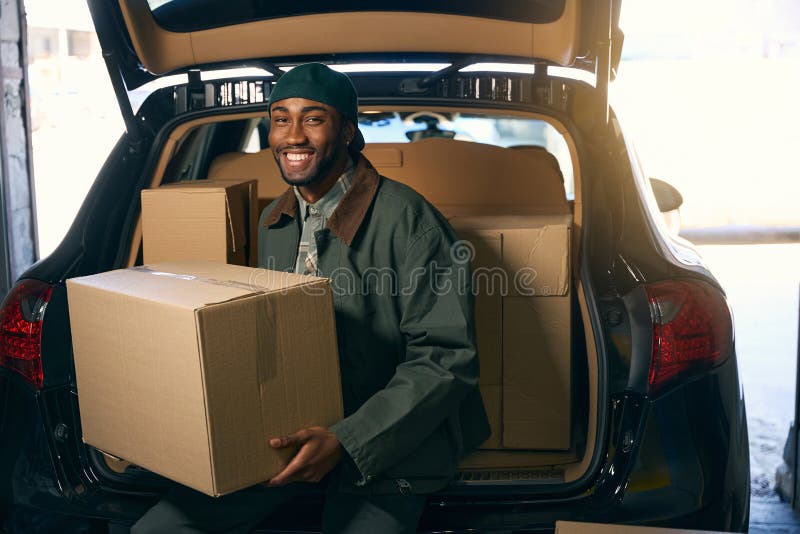 Man is Sitting in the Trunk of a Car, Holding a Box in His Hands Stock ...
