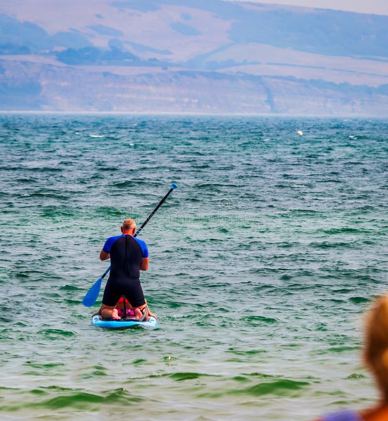Man Sitting and Using Paddle Board in Weymouth Beachfront England ...