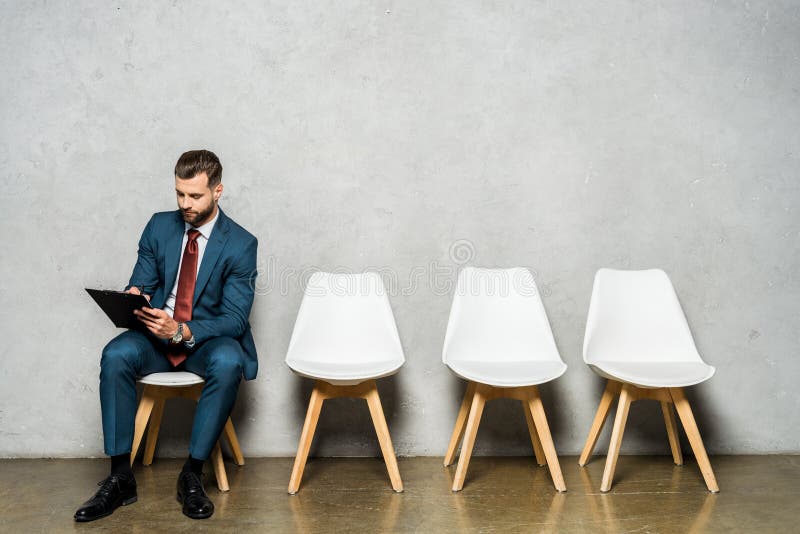 Man Sitting on White Chair and Holding Clipboard Stock Image - Image of ...