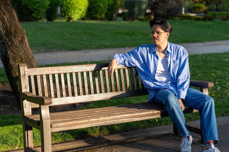 Man Sitting on a Wooden Bench in a Park on a Sunny Day Stock Photo ...