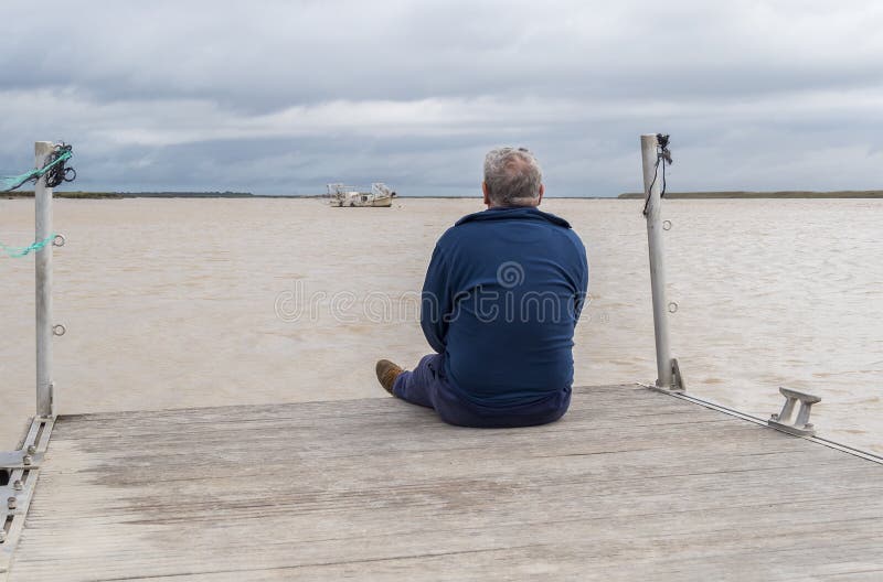Man Sitting on Wooden Pier Facing the River Thinking Stock Image ...