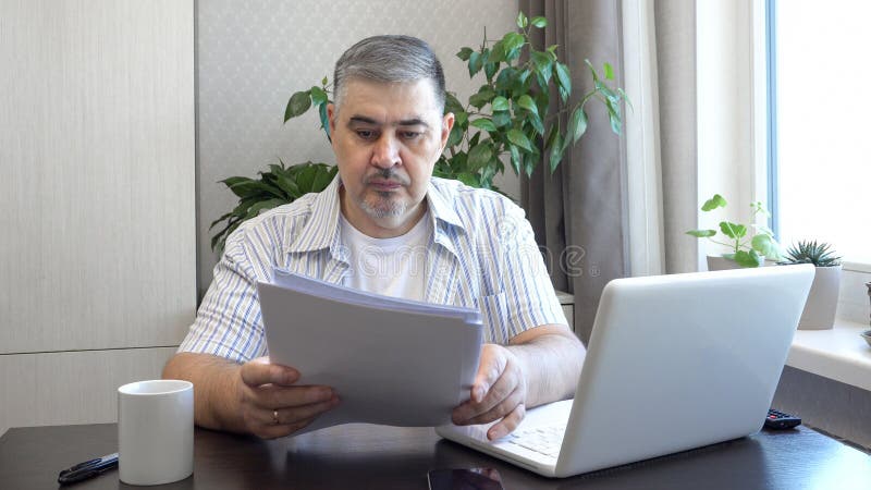 Man Reading Documents at Work Desk Stock Photo - Image of remote ...