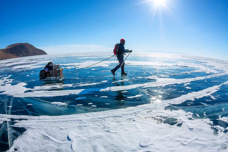 Man with a Sledge and Trekking Pole is on the Ice of Lake Baikal Stock ...