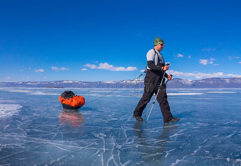 Man with a Sledge and Trekking Pole is on the Ice of Lake Baikal Stock ...