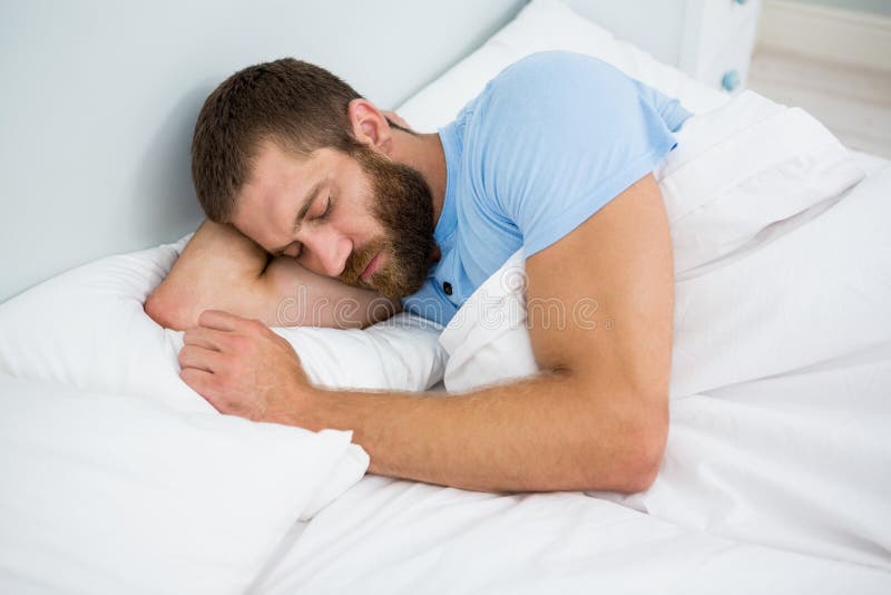 Man sleeping on bed stock image. Image of handsome, homey - 69792311