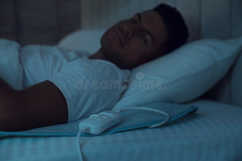 Man Sleeping in Bed with Electric Heating Pad, Focus on Cable Stock ...