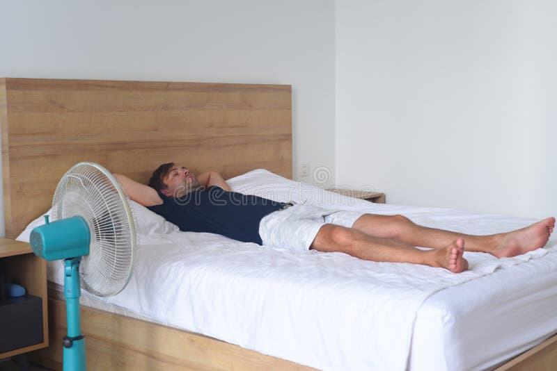 Man Sleeping on a Bed with Fan Stock Image - Image of calm, home: 252949189