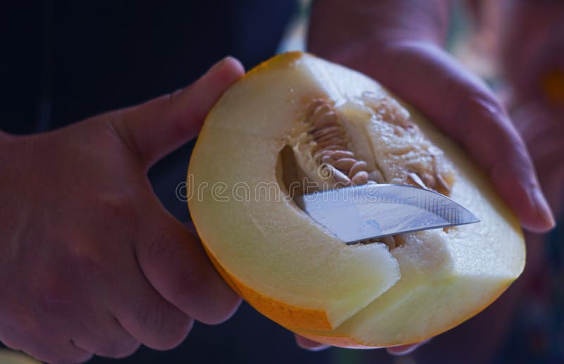 A man is slicing a melon stock image. Image of table - 254373123