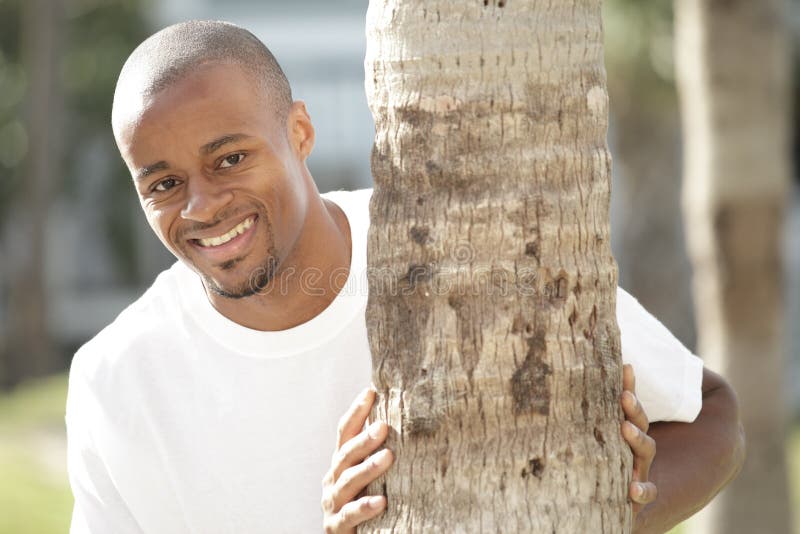 Man Smiling from Behind a Tree Stock Image - Image of model, shaved ...