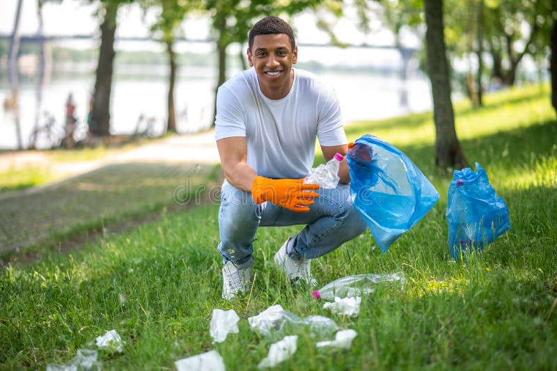 Man Smiling at Camera Putting Garbage in Bag Stock Image - Image of ...