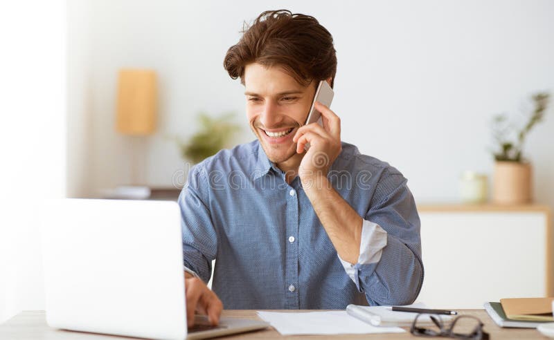 Man Talking on Phone while Working on Laptop Stock Photo - Image of ...
