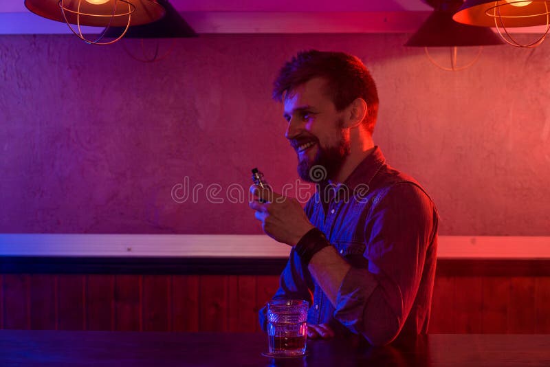 The Man Smoke an Electronic Cigarette at the Vape Shop. Stock Image ...